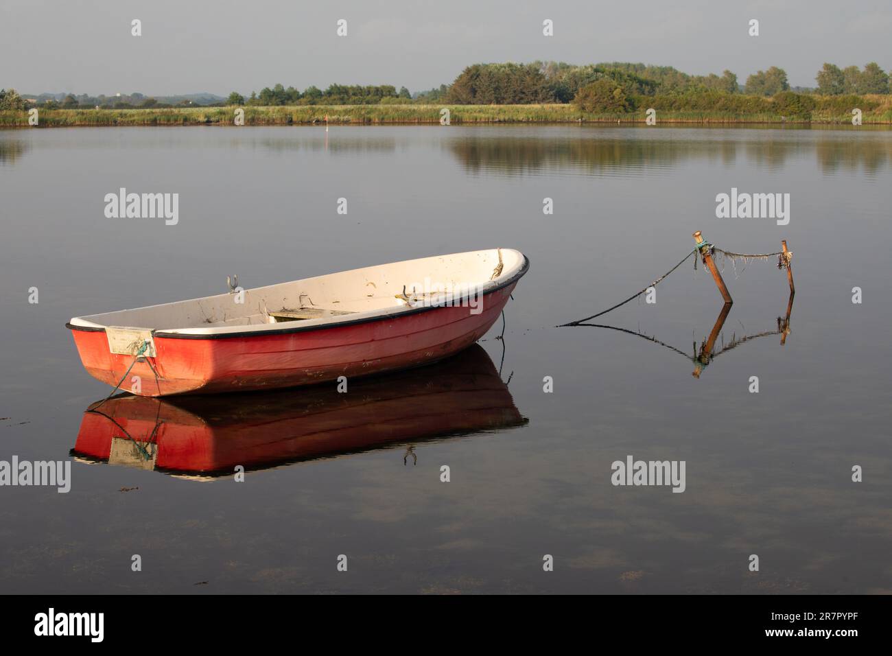 Dinghy reflected in calm water at Agernaes, Funen, Denmark Stock Photo ...