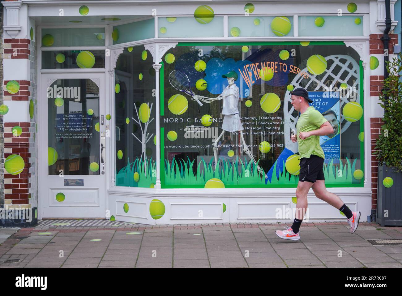 London UK. 17 June 2023 . A shop window decorated with tennis balls ...