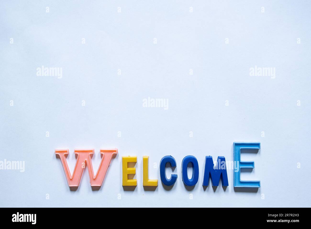 The word "WELCOME" is created by arranging a set of 3D colorful plastic ...