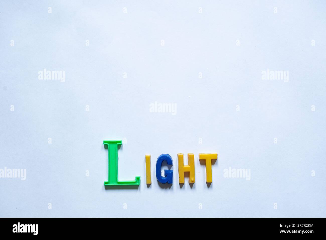 The word "LIGHT" is created by arranging a set of 3D colorful plastic ...