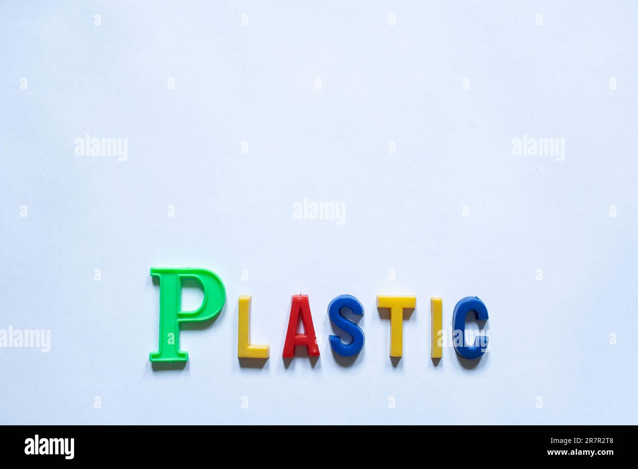 The word "PLASTIC" is created by arranging a set of 3D colorful plastic ...