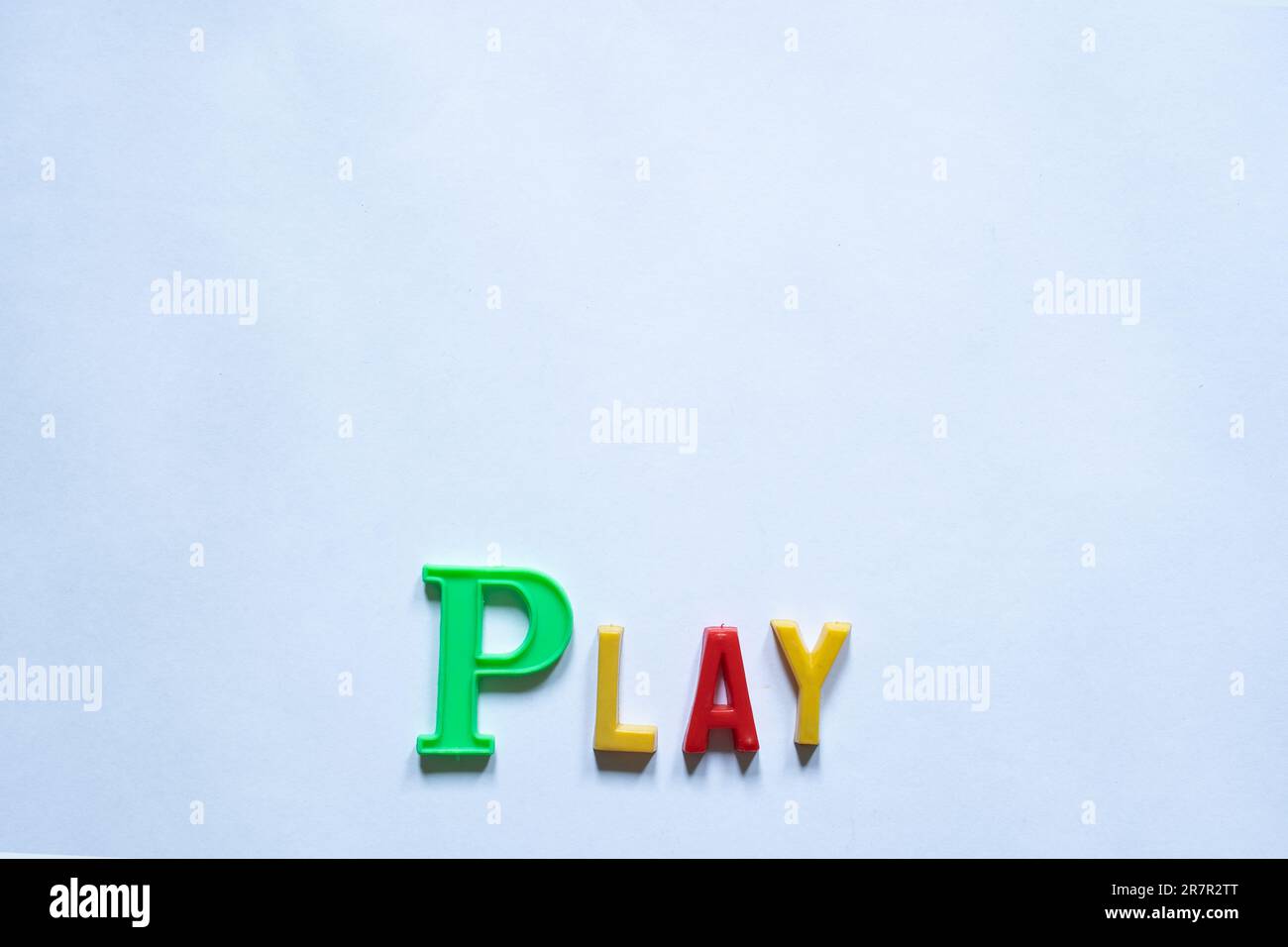 The word "PLAY" is created by arranging a set of 3D colorful plastic ...