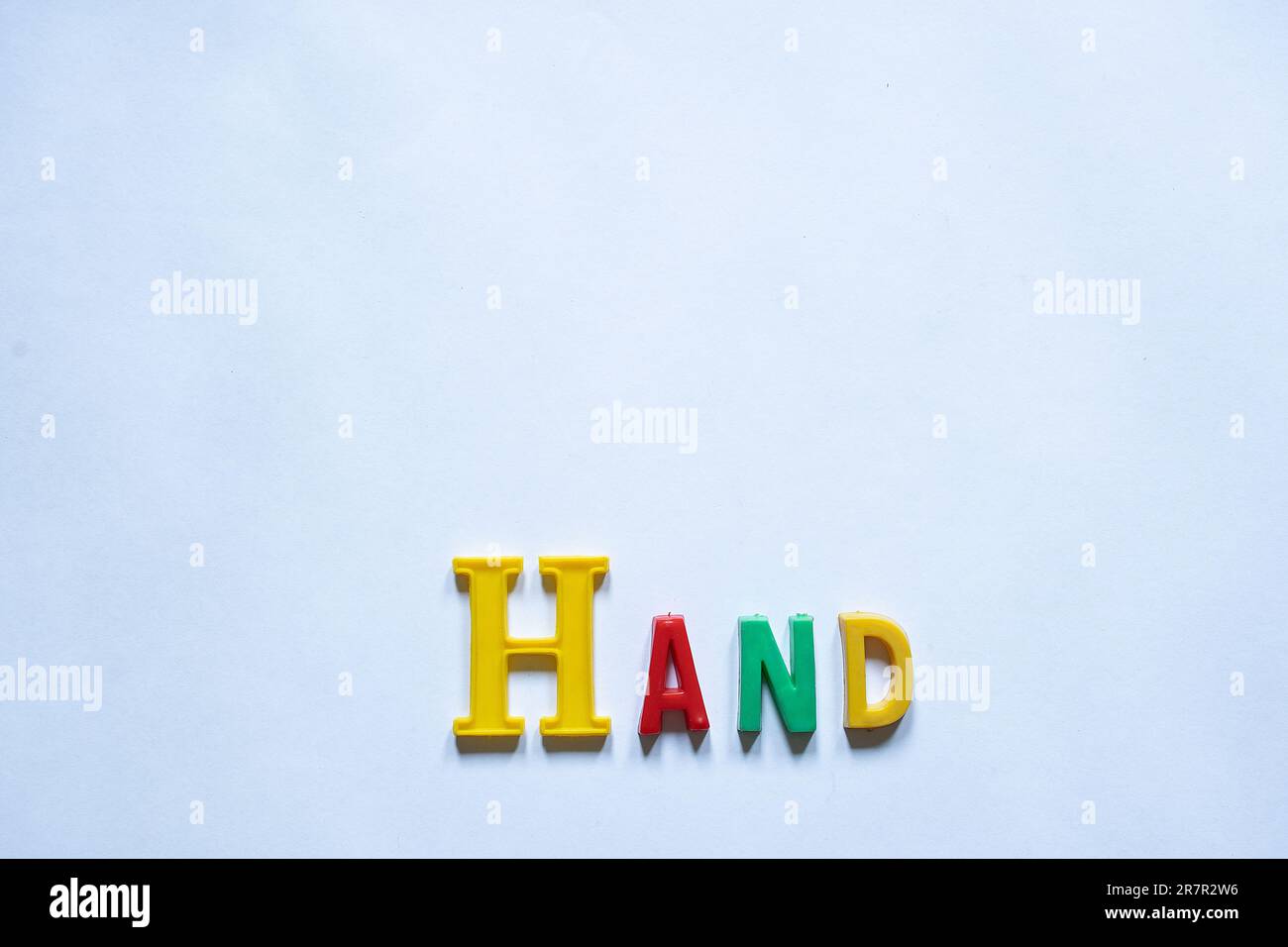 The word "HAND" is created by arranging a set of 3D colorful plastic ...