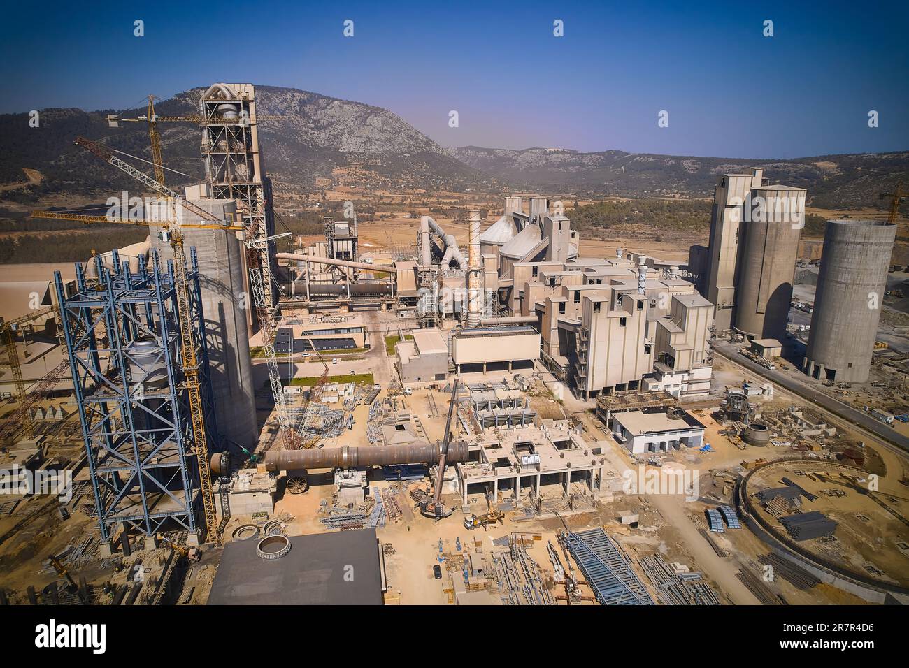 Huge cement producing plant. Aerial view of silos towers, pipes and ...