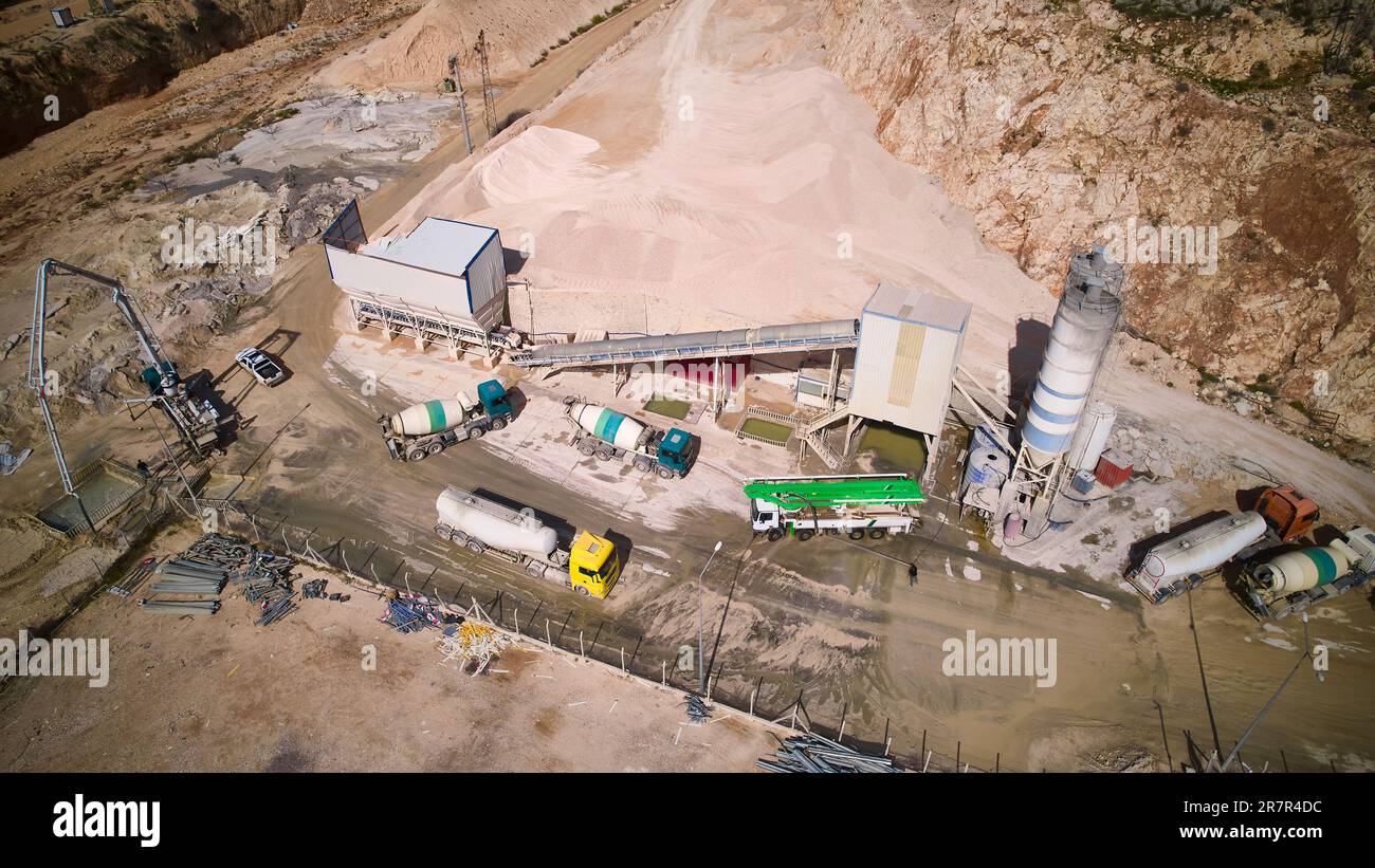 Aerial view of concrete mixing trucks and siloses of plant producing ...