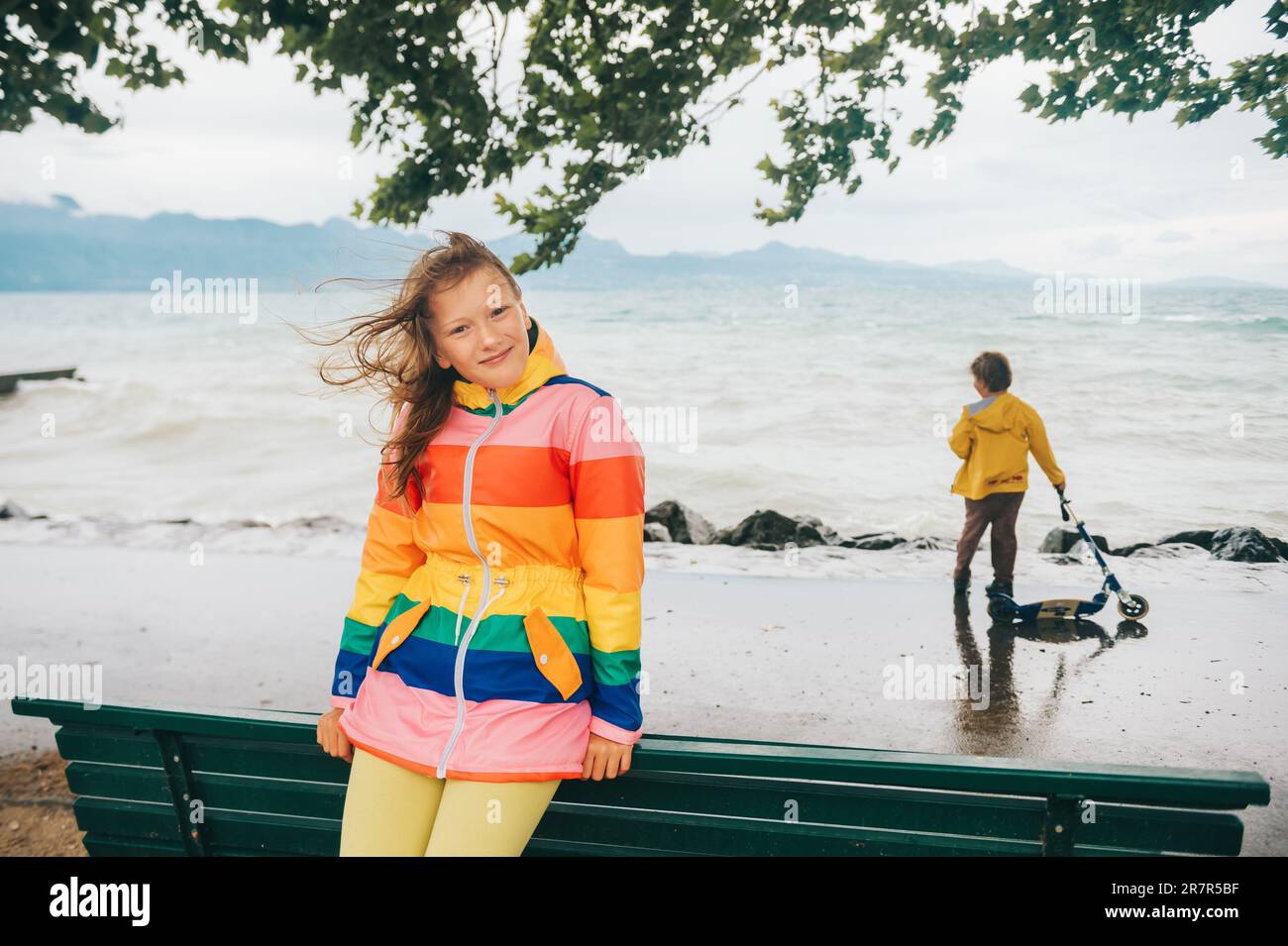 Group of two funny kids playing by the lake on a very windy day ...