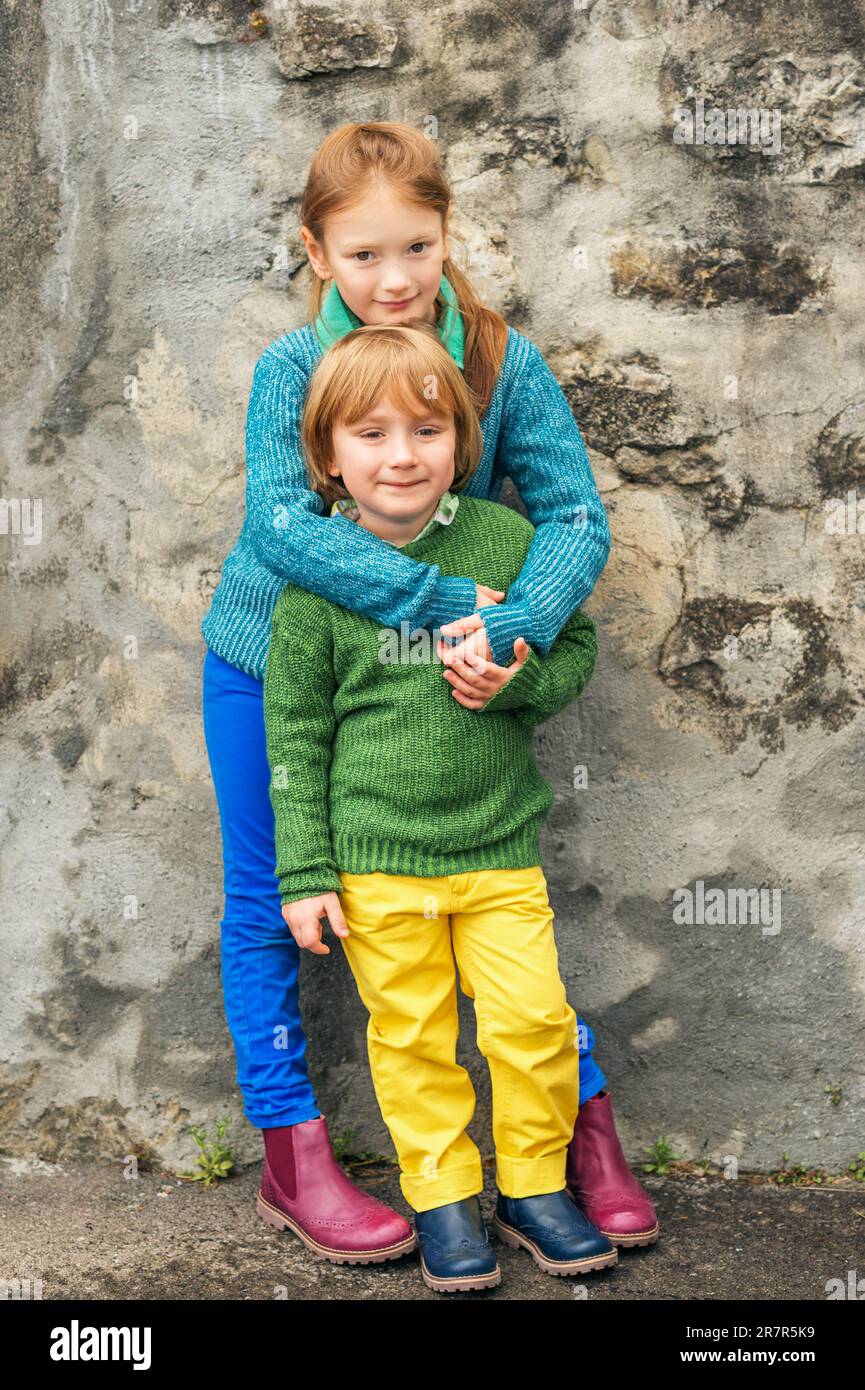 Outdoor portrait of two little kids, brother and sister, wearing ...