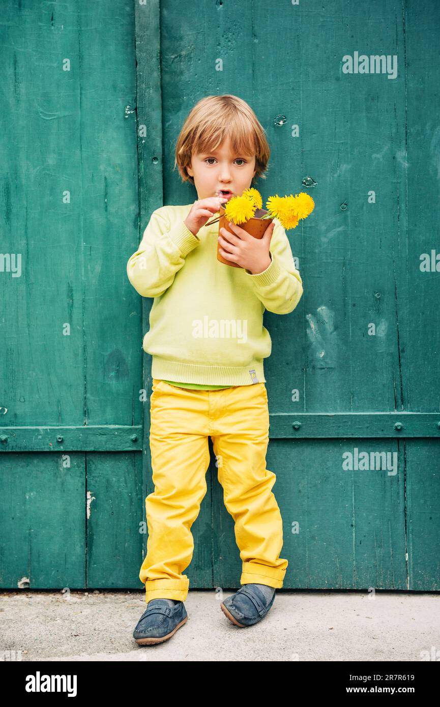 Outdoor portrait of a cute little boy, wearing yellow pullover and ...