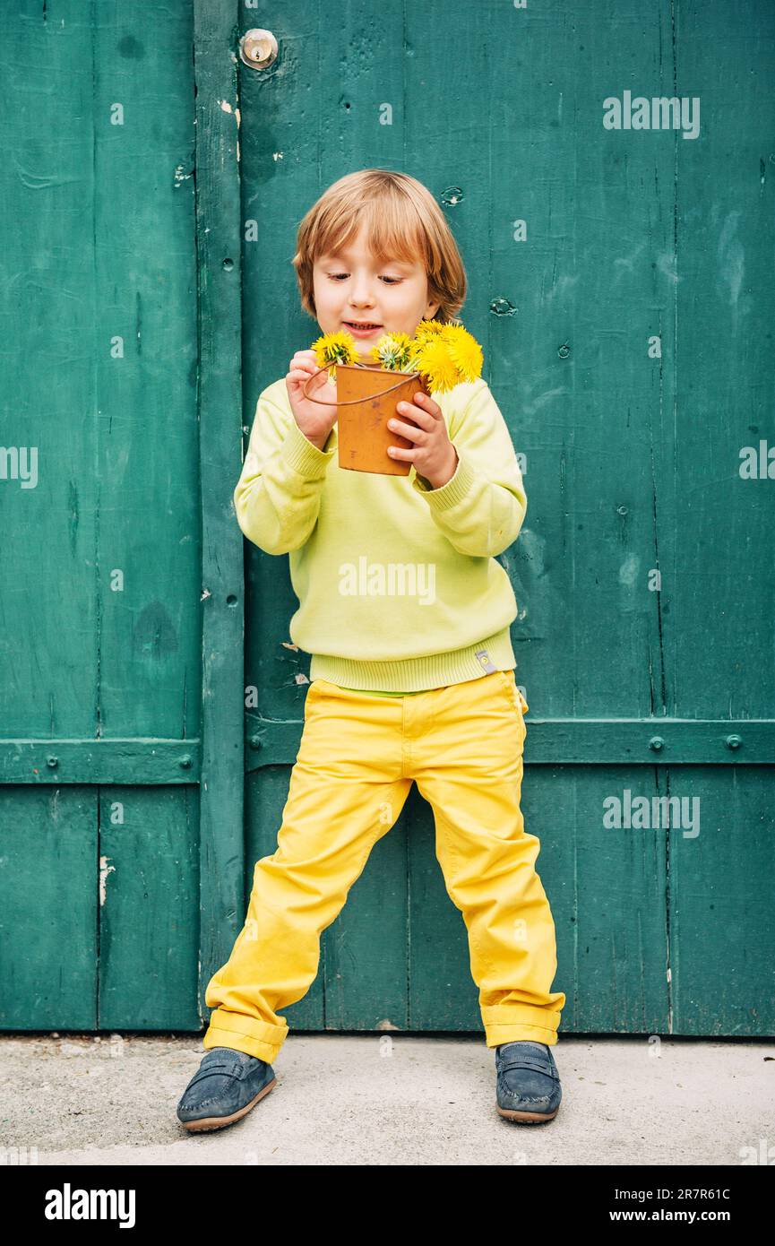 Outdoor portrait of a cute little boy, wearing yellow pullover and ...