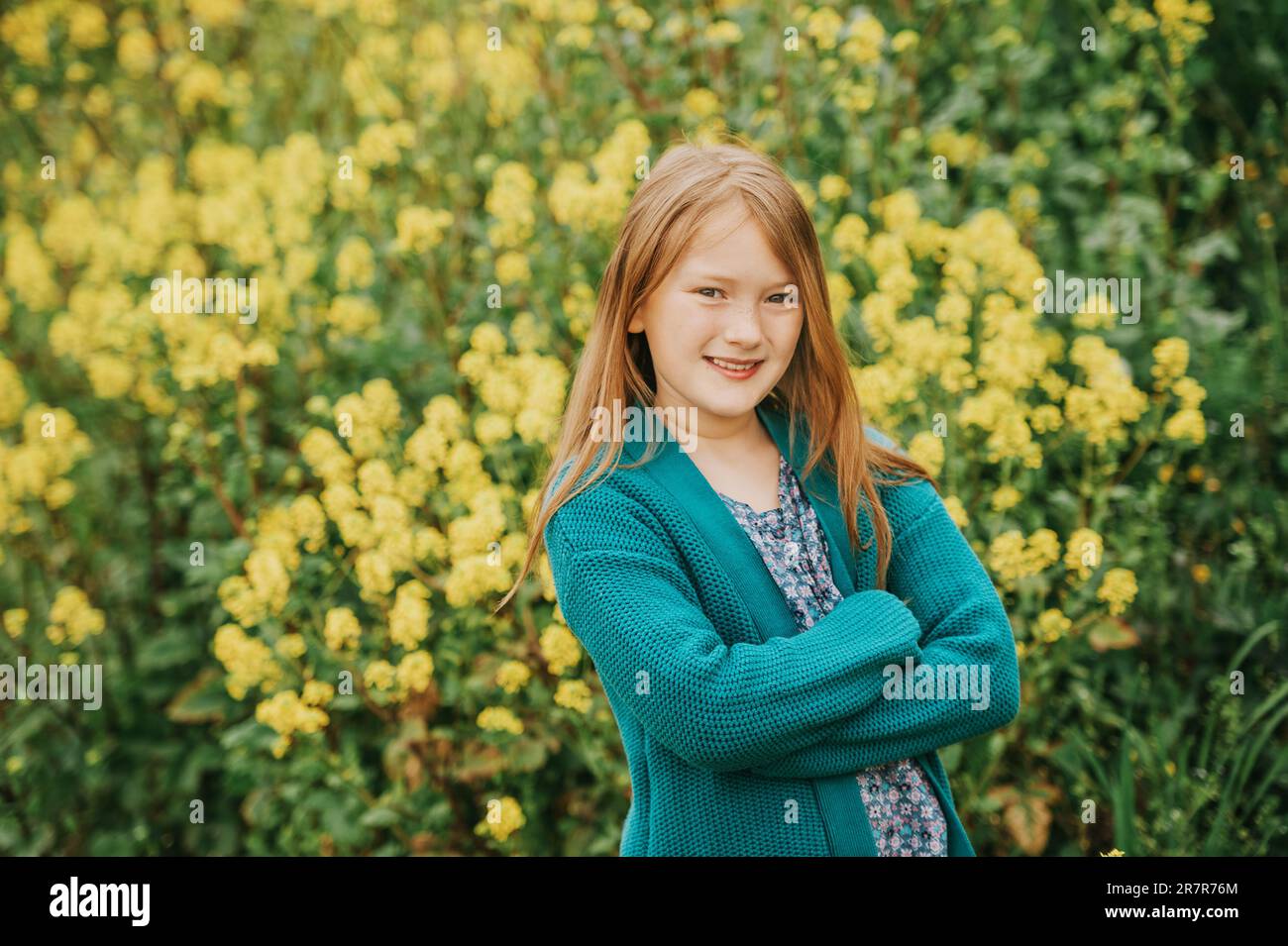 Outdoor spring portrait of cute 6-7 year old girl playing in yellow ...
