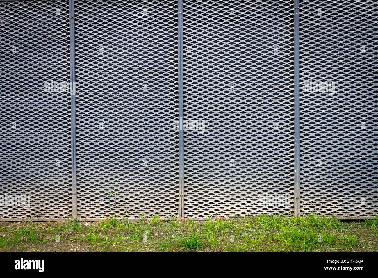 Iron grid wall and green grass. Architecture detail background Stock ...