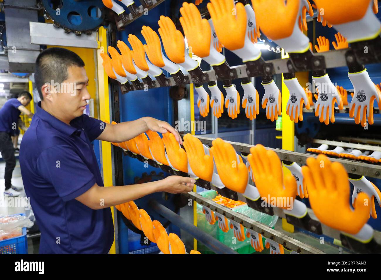 A worker works on the production line of a labor protection gloves ...