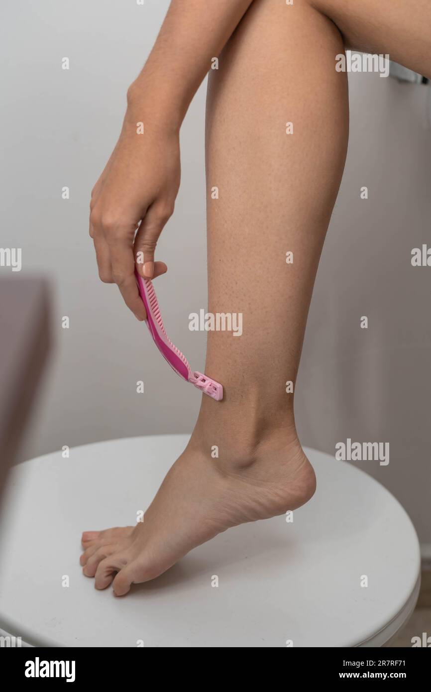 person shaving his legs with a razor blade, female beauty treatments ...