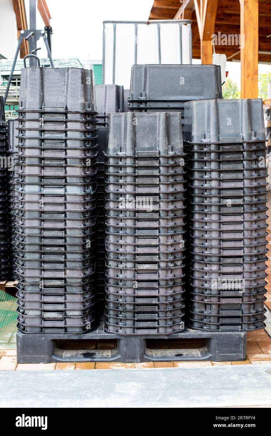 Stocks of black plastic boxes on plastic palette Stock Photo - Alamy