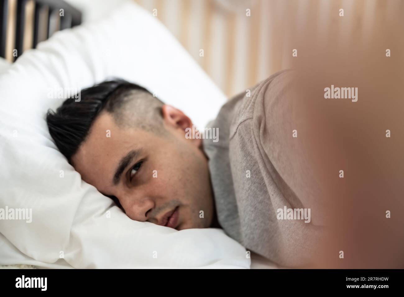 Lazy man oversleep, wake up late, hit the alarm clock frequently with ...