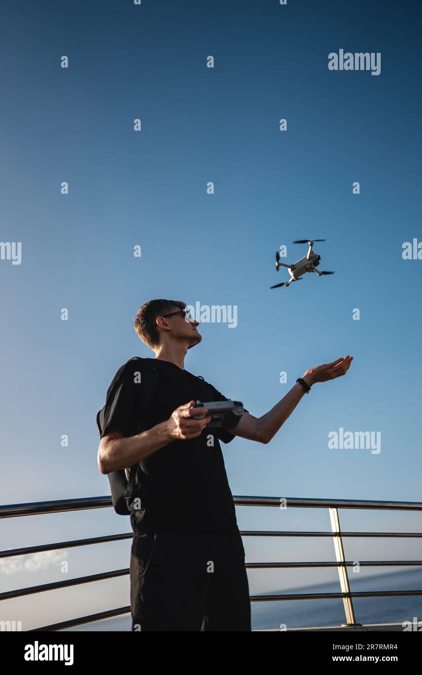 young photographer launching quadcopter drone from hand with remote controller Stock Photo - Alamy