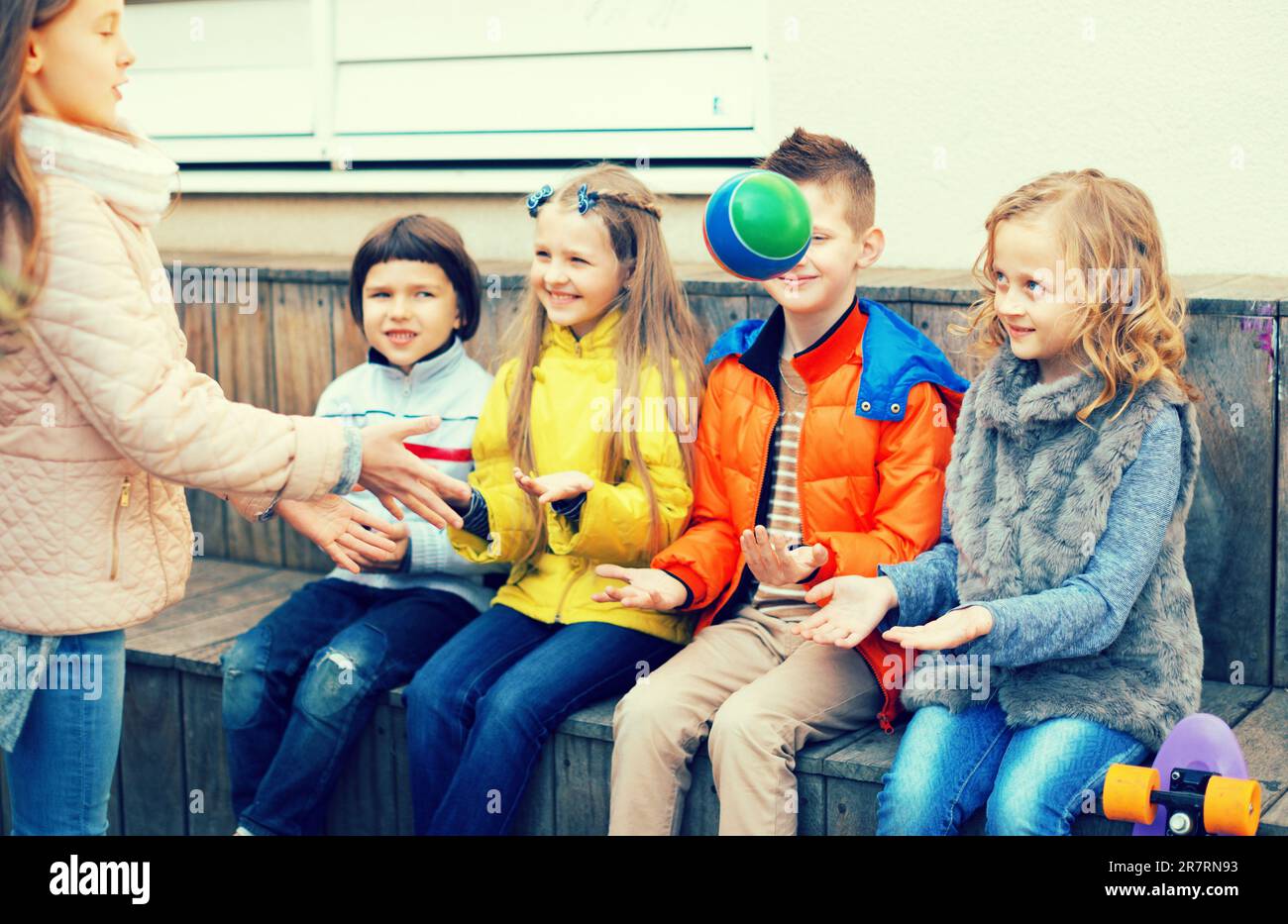 children playing with Ball on bench Stock Photo - Alamy