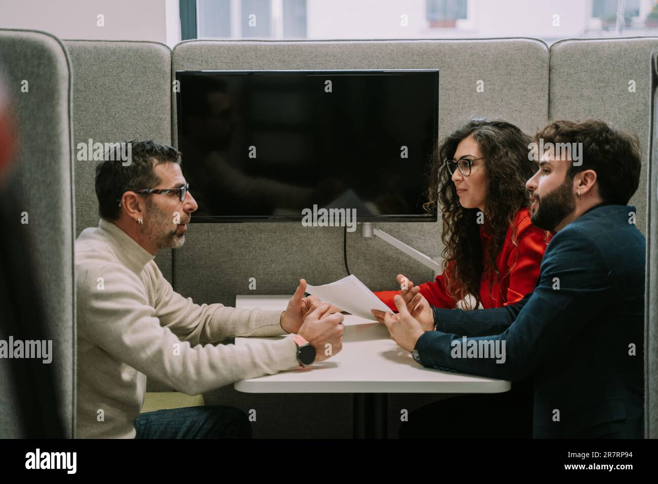 Two beautiful young colleagues, male and female, getting taught sales ...