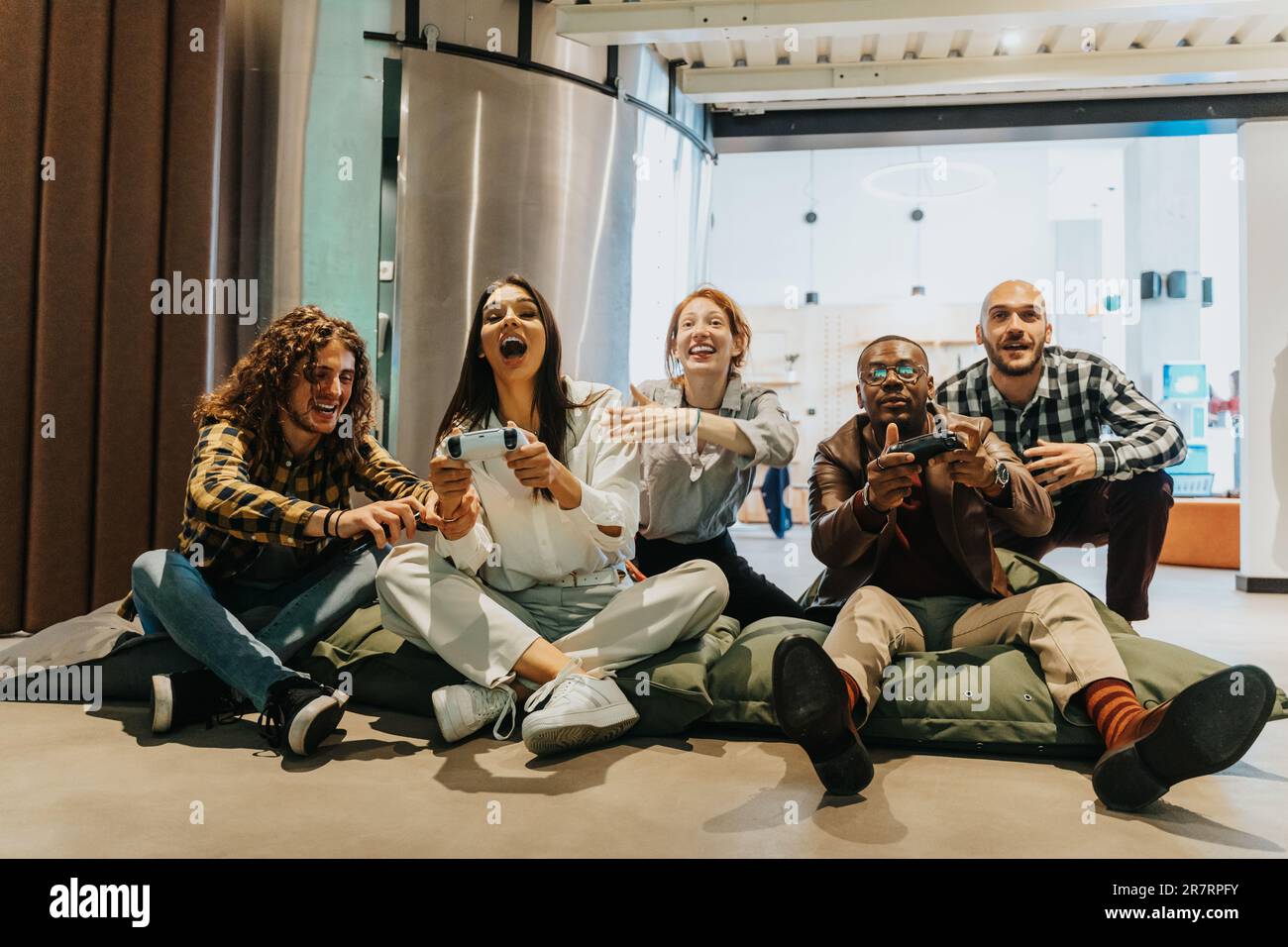 Young, attractive multiracial colleagues playing games at work while ...