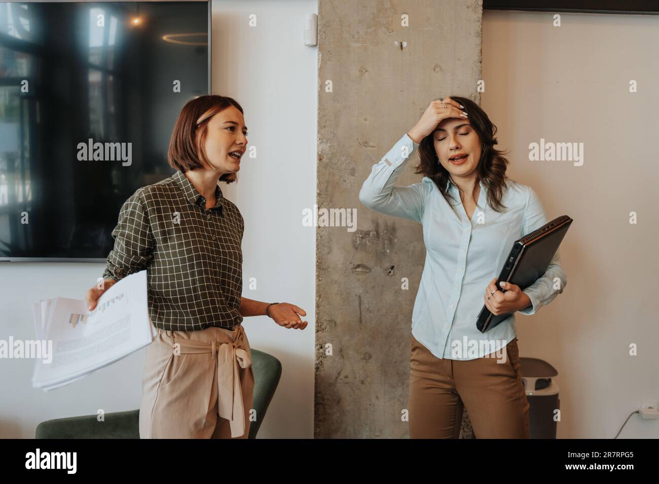 Two young business girls made a big mistake at the project. Brunette ...