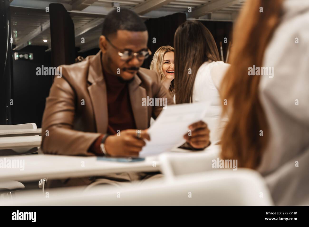 Two female employees having a conversation and laughing while their ...
