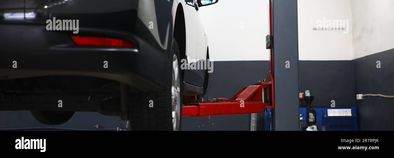 Modern car on lift in service center Stock Photo - Alamy