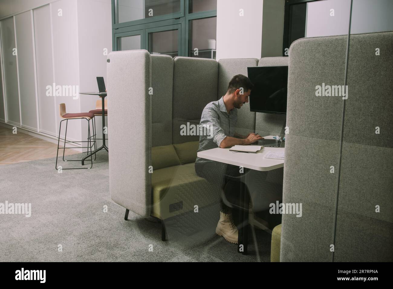 A good looking male person with slight smile on his face working at ...