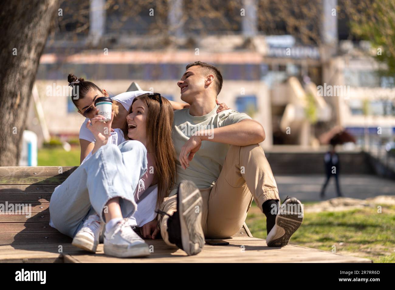 Happy group of three friends laughing and talking in the street Stock ...