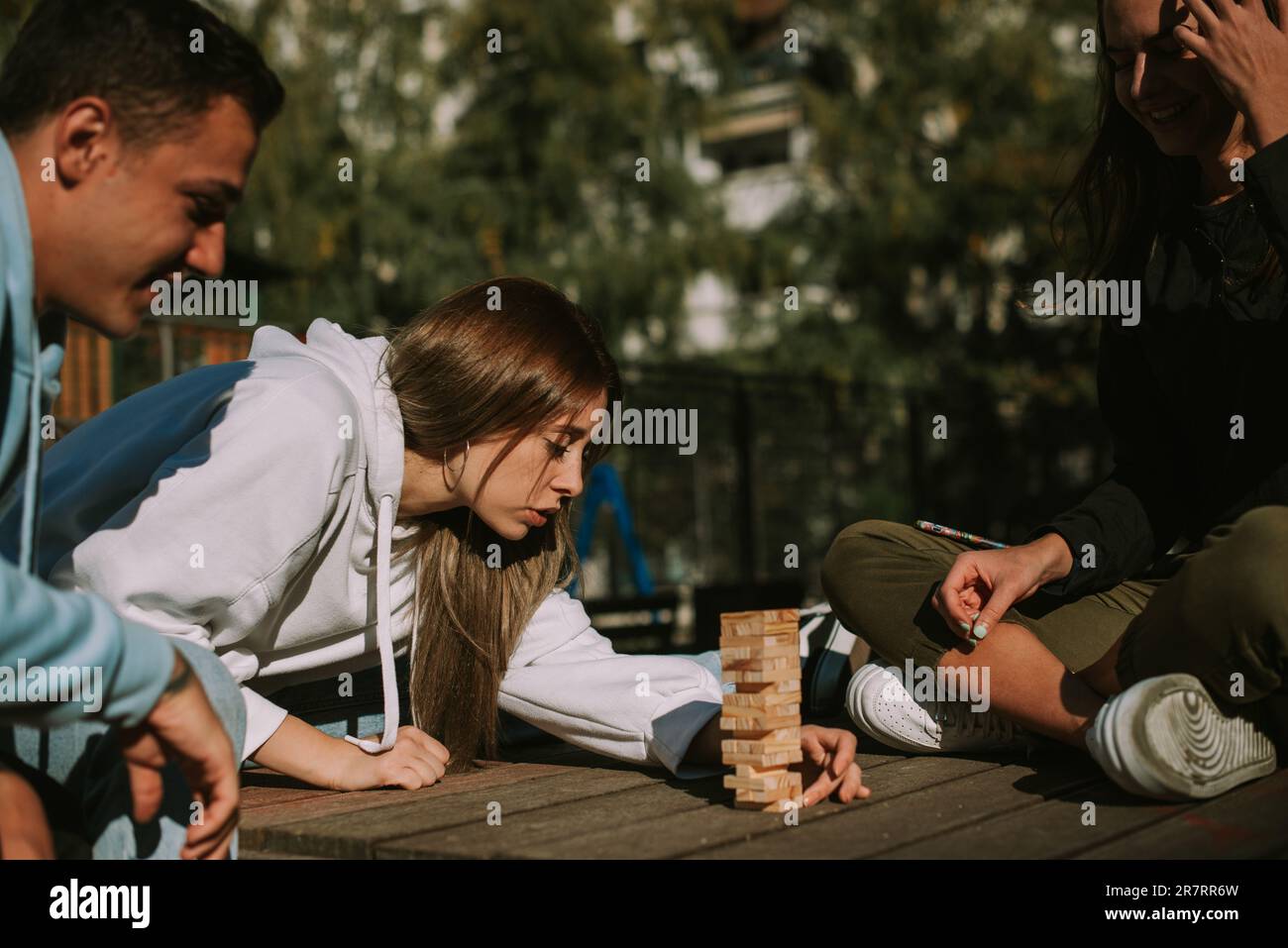 Close up of beautiful blonde girl playing jenga with her besties on the ...