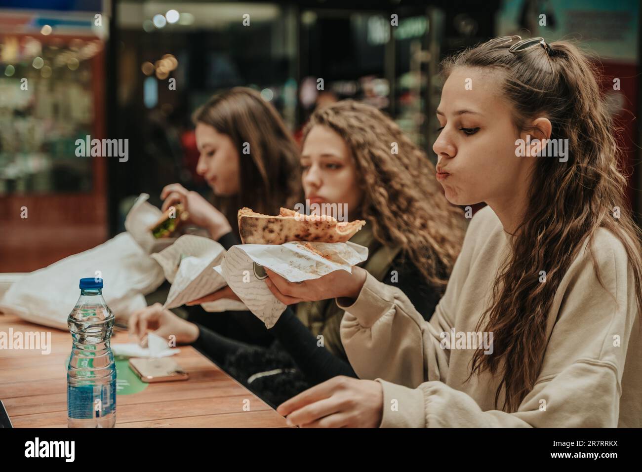 Three girls eating pizza Stock Photo - Alamy