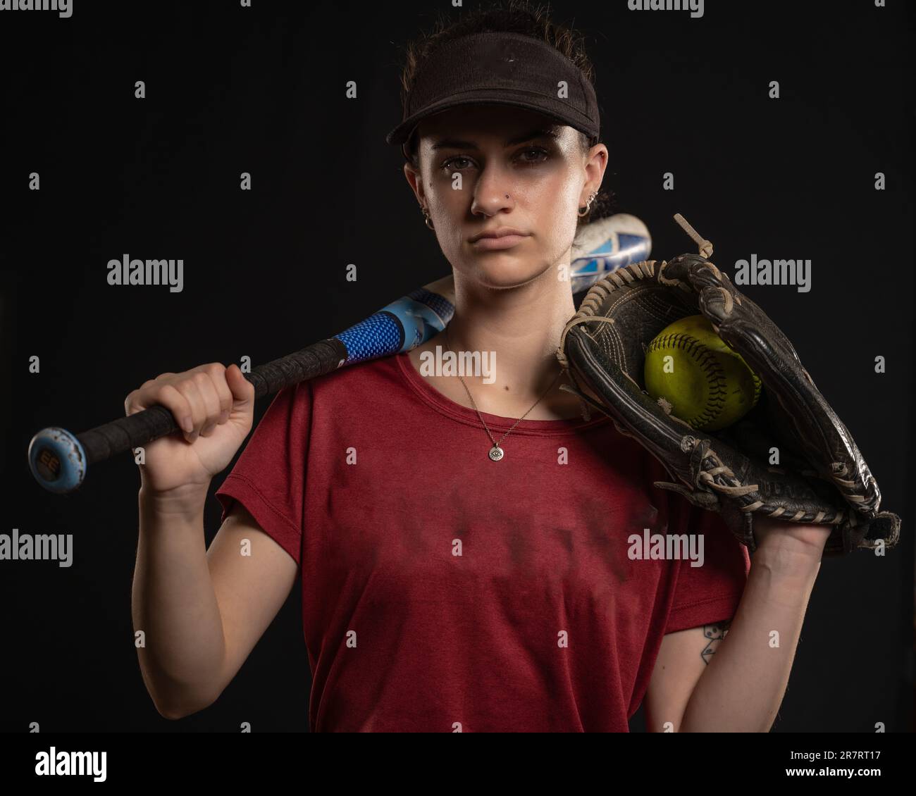 Athletic fast pitch softball player in red and black uniform shows her ...