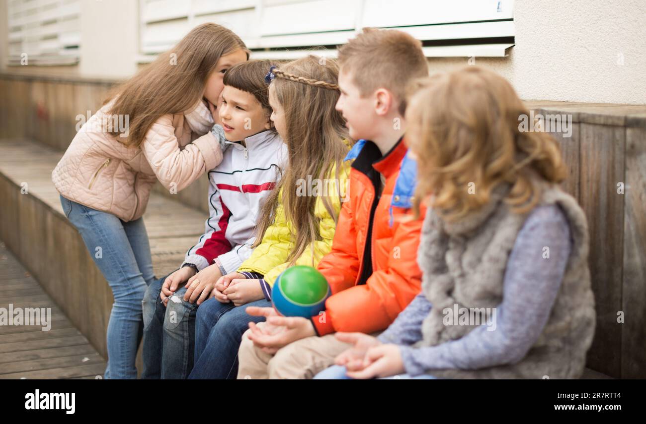 Children on a bench playing Chinese whispers Stock Photo - Alamy