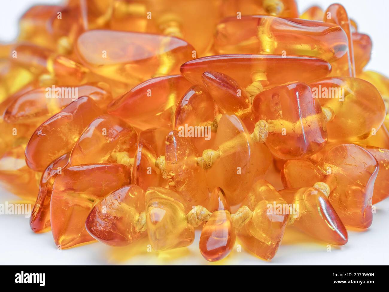 Macro of amber necklaces wrapped in a circle on a white background ...