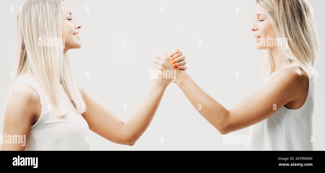 Two blonde women sharing a secret handshake, reinforcing their bond ...