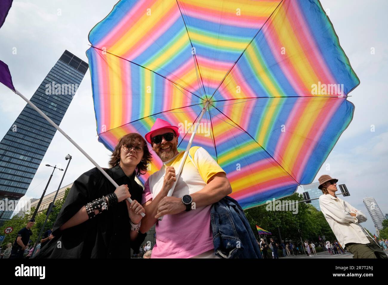 People smile under the rainbow umbrella during the yearly pride parade ...