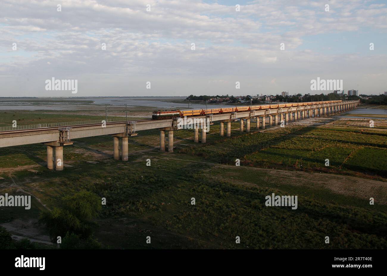 An Indian passenger train passes over a bridge on river Ganges in ...