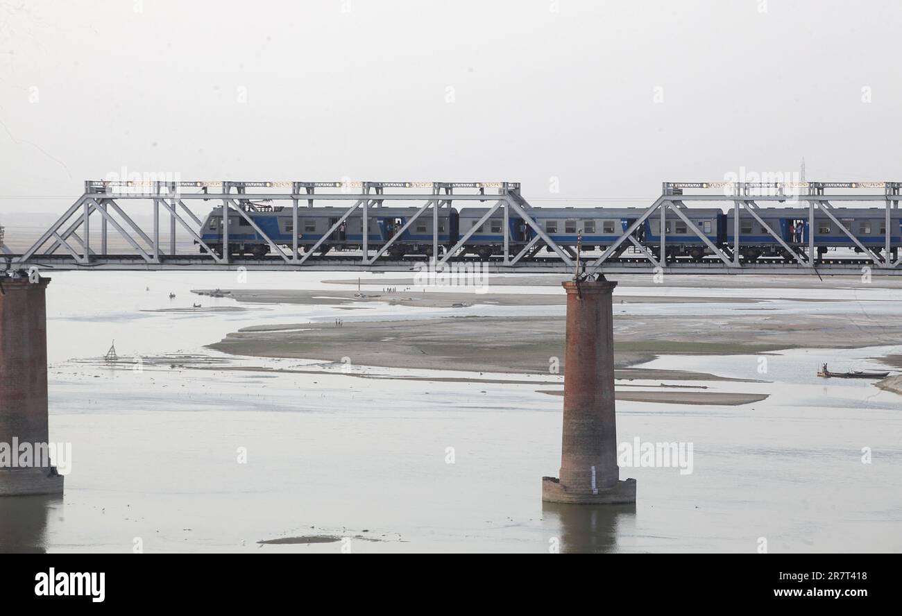 An Indian passenger train passes over a bridge on river Ganges in ...