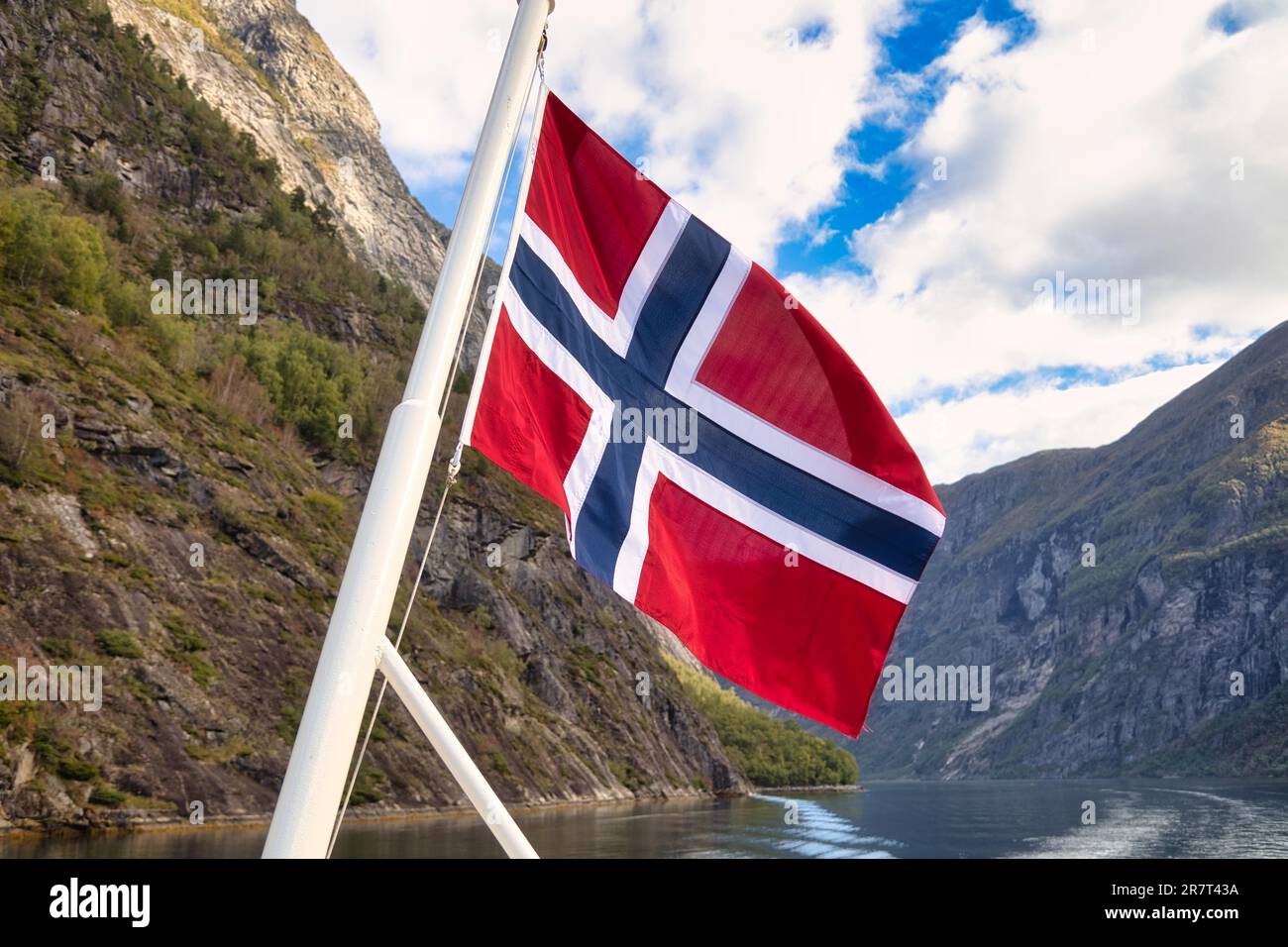 Norwegian flag in front of mountain panorama in Geirangerfjord near ...