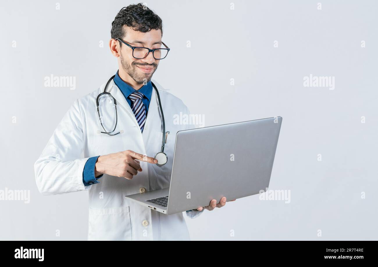 Young doctor in glasses using notebook on isolated background. Handsome ...