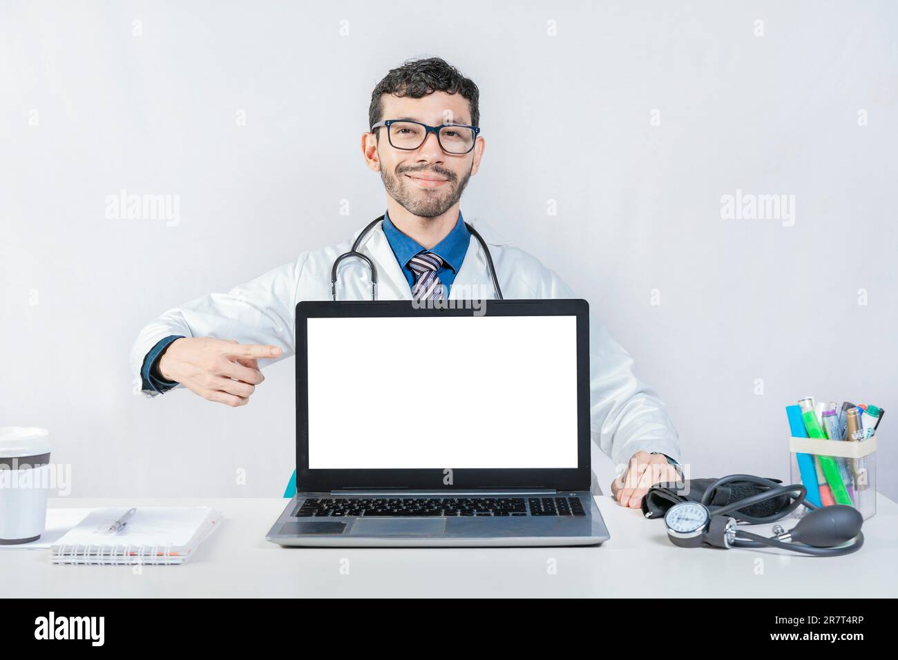 Smiling doctor pointing at an advertisement on the laptop screen ...