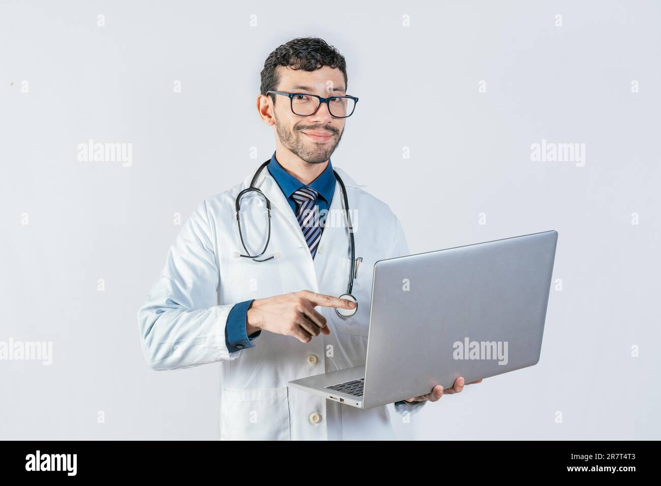 Smiling doctor using and pointing laptop isolated. Young doctor in ...