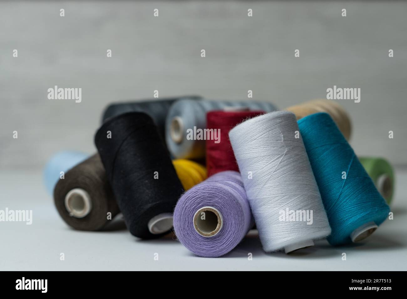 Spools of colored sewing thread on white background with copy space ...
