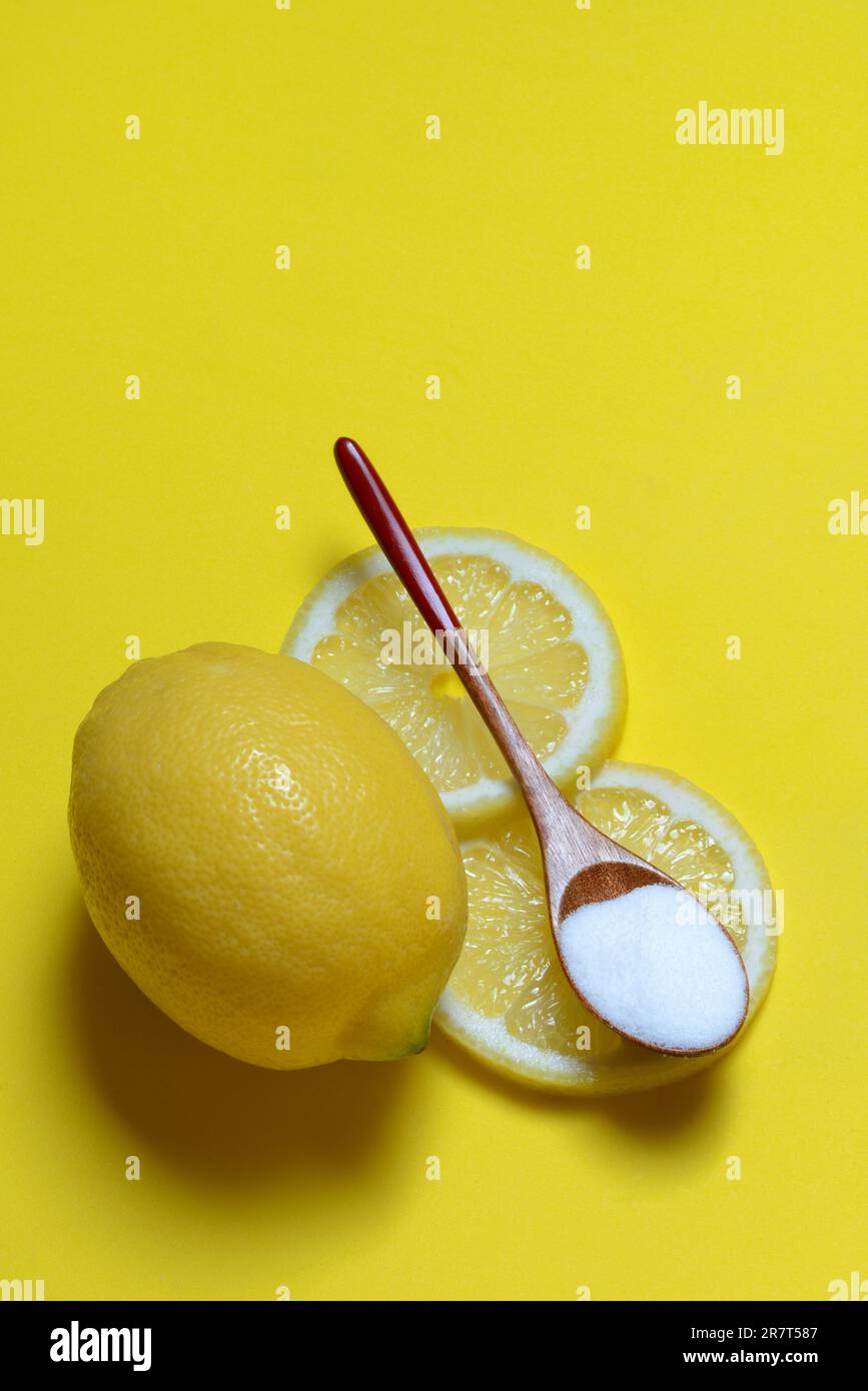 Citric acid in wooden spoon and lemon Stock Photo - Alamy