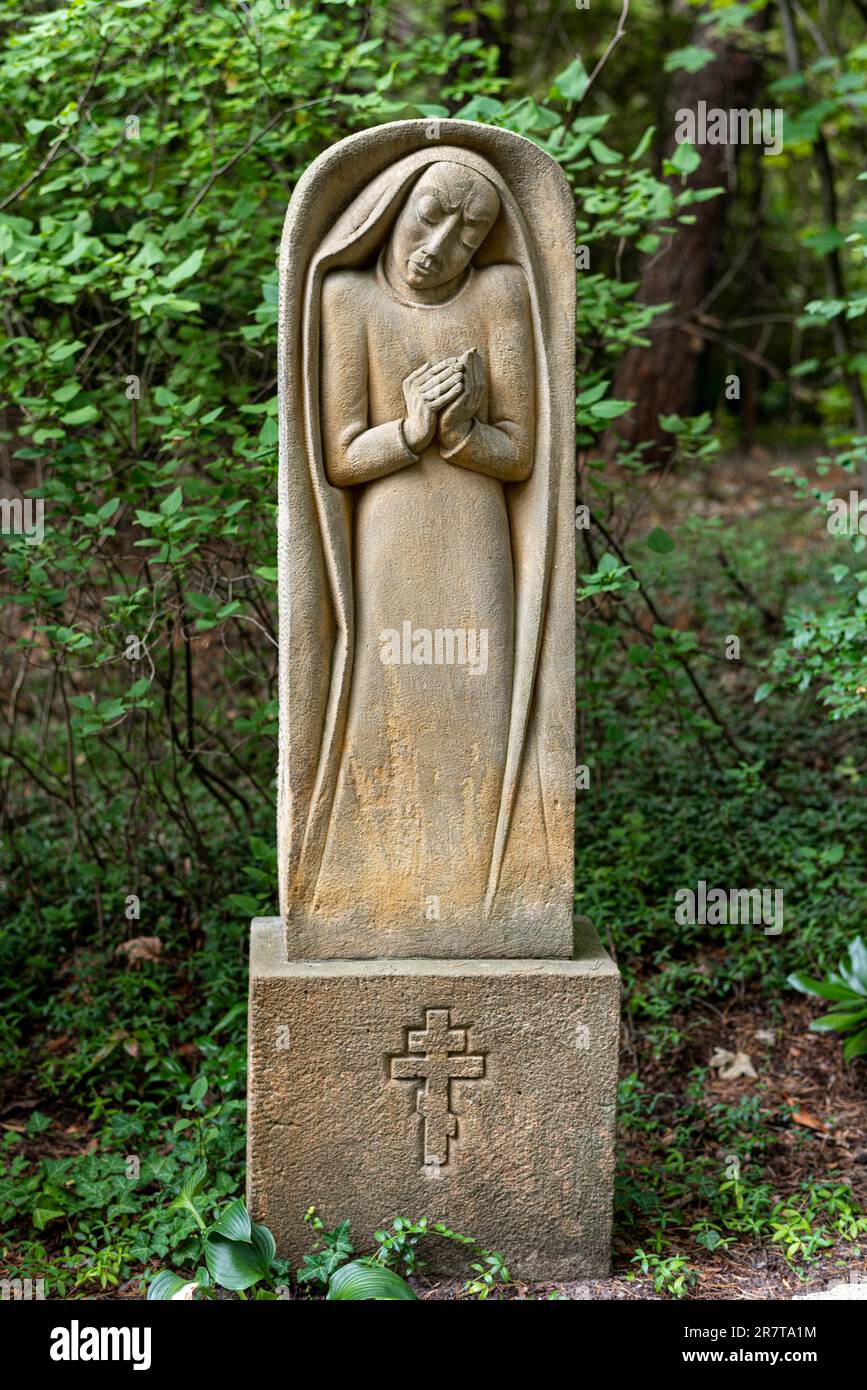 Statue and tomb stone with praying woman and three-barred cross of the ...