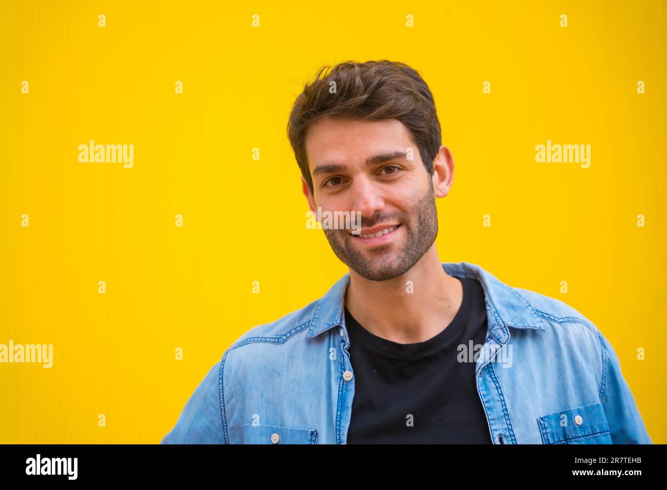 Portrait of a handsome excited model man in basic clothes smiling ...