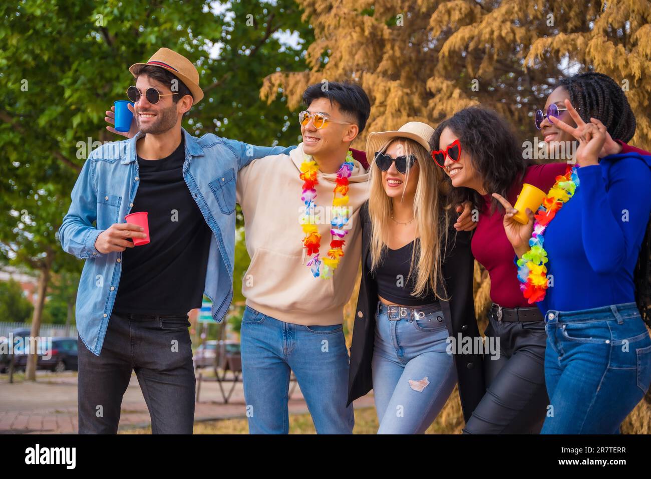 Group portrait of multi ethnic friends having a party in a park ...