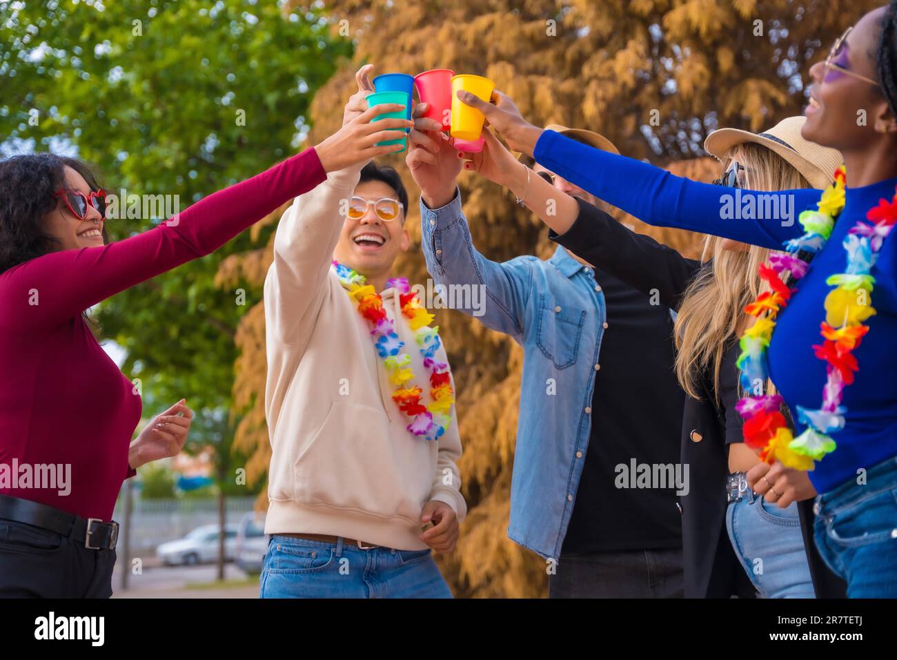 Group of multi ethnic friends partying in a park, Diverse young people ...