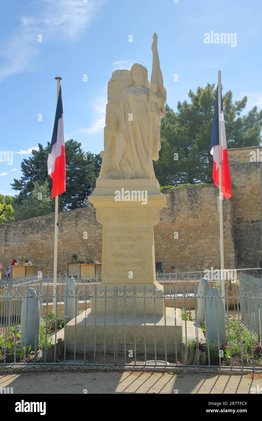 Monument with white statue with sword and two French national flags ...