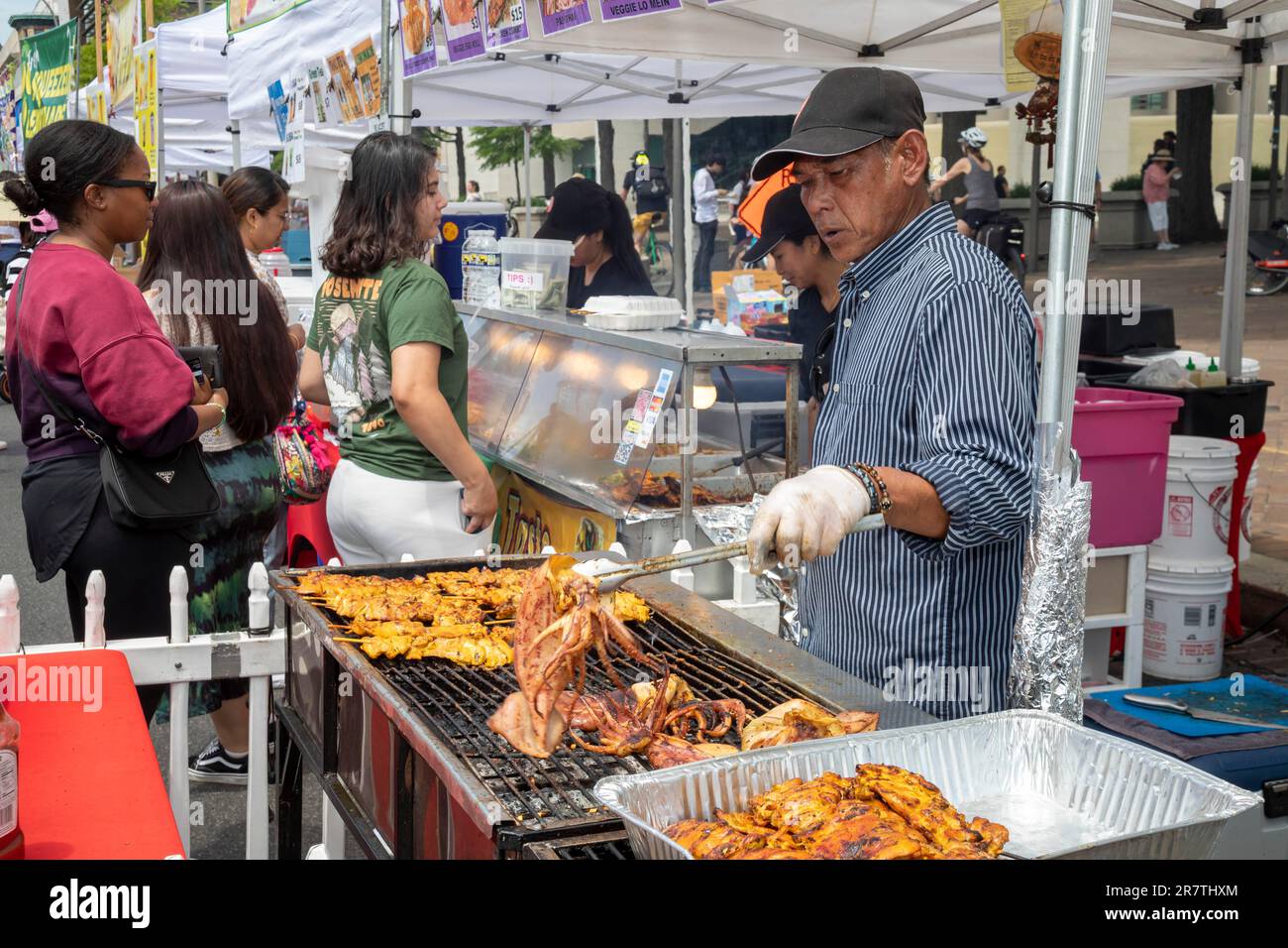 Washington, DC, A man grills squid at a food stand at the Fiesta Asia ...