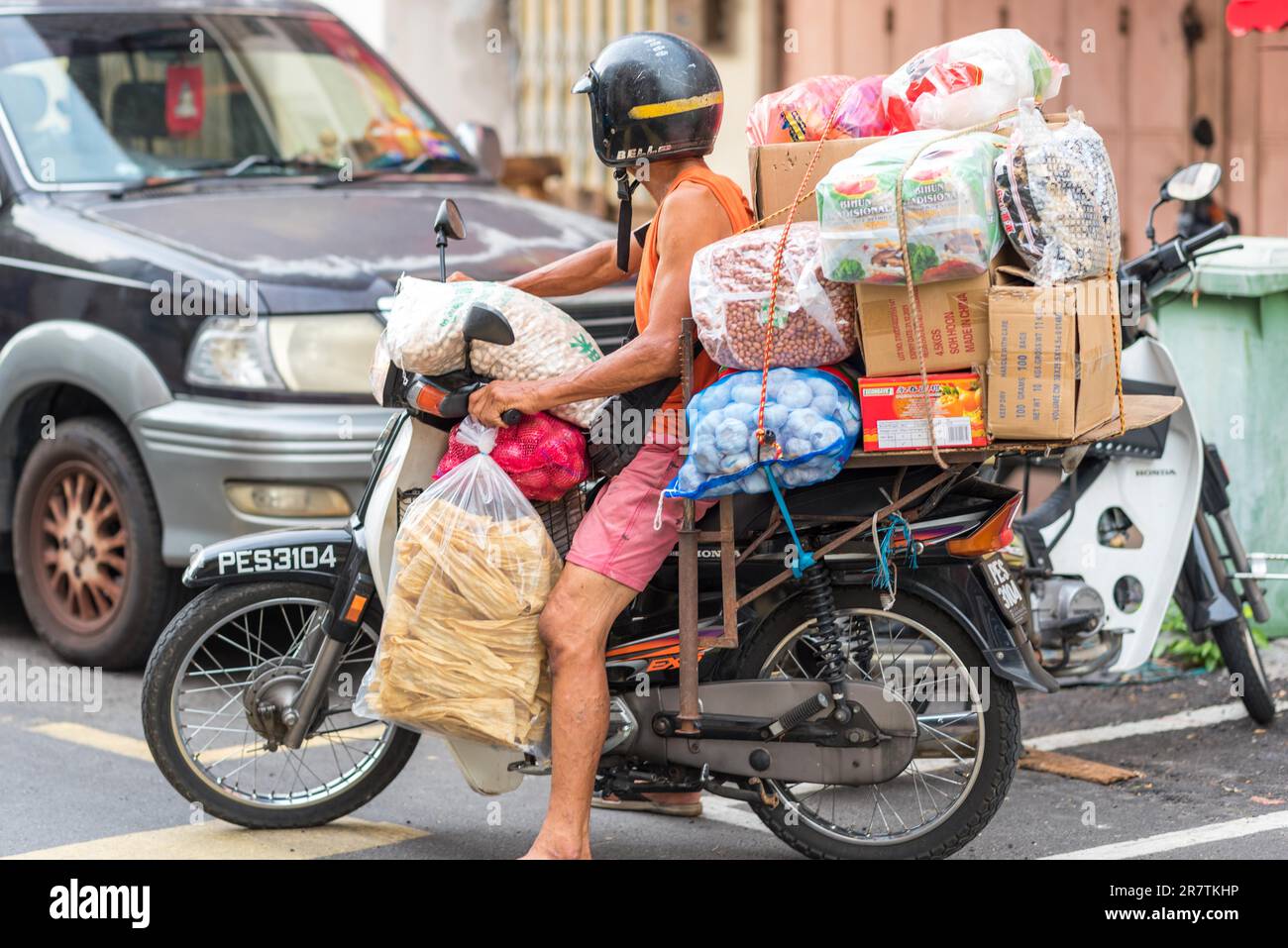 Overloaded motorbike with lots of goods delivered by a driver in the ...